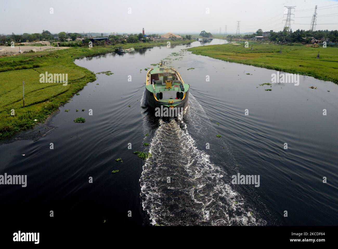 People cross on boat over the pitch black water of the polluted Turag ...