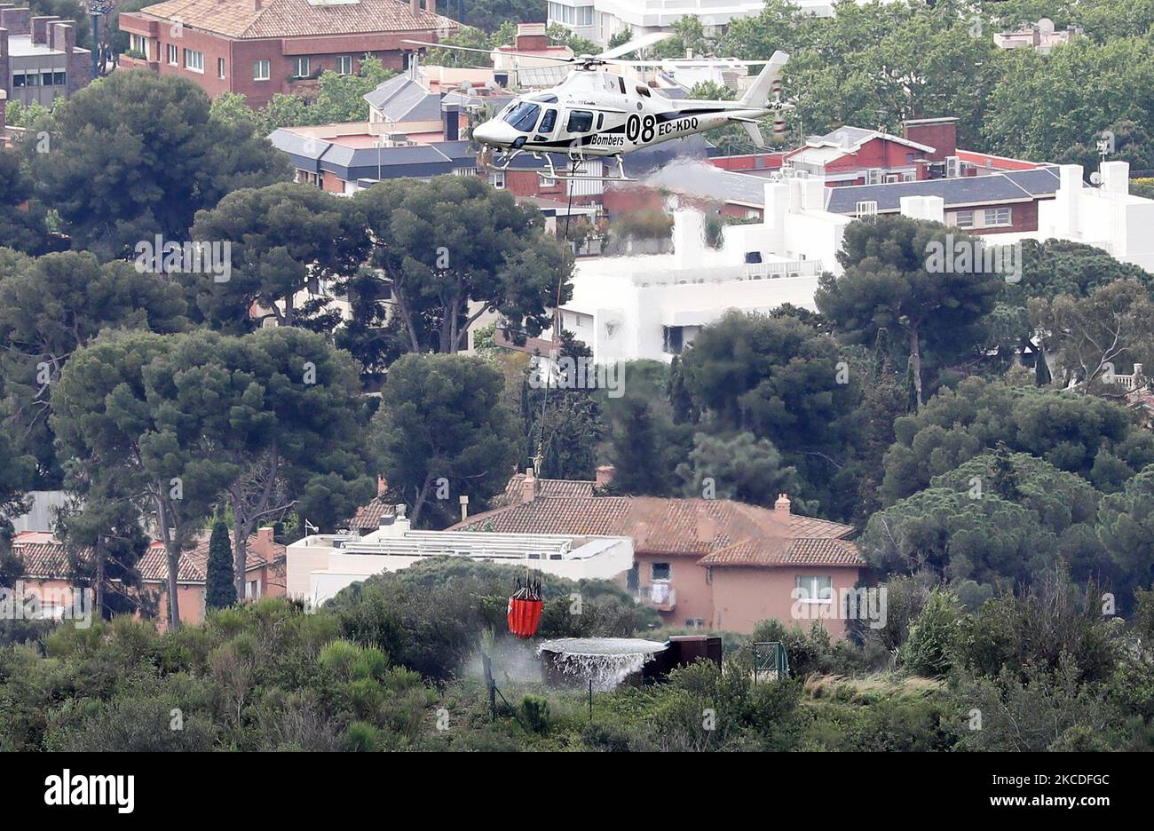 Helicopter collecting water from a pool to put out a fire in the ...