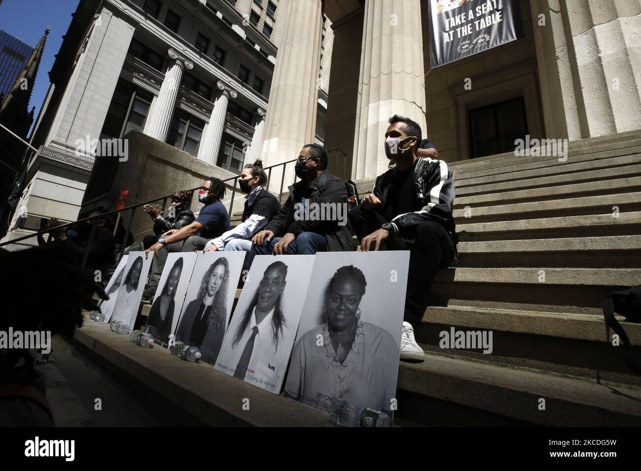 People holding up signs rally on the steps of Federal Hall to raise ...