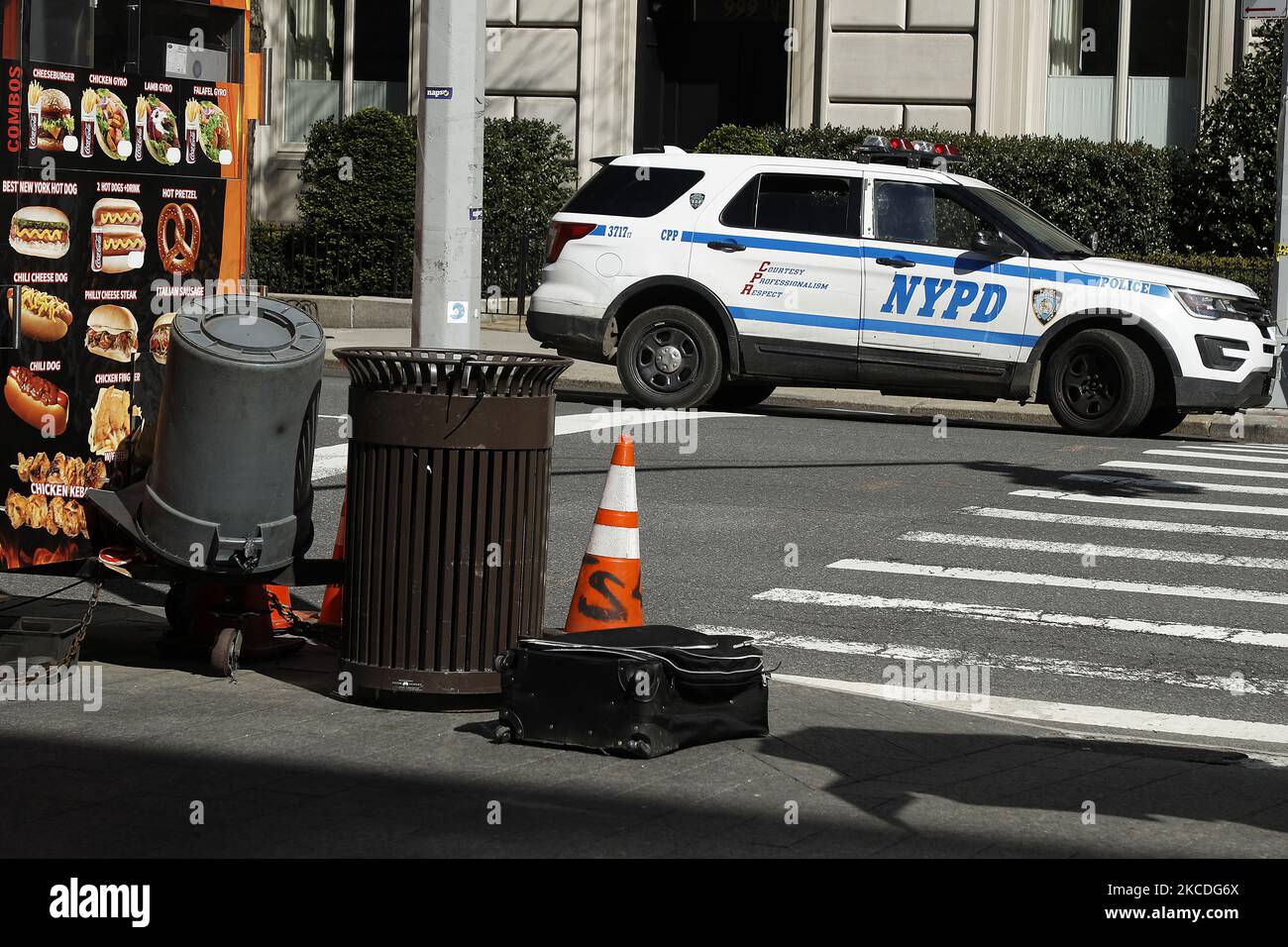 A police car drives past a suitcse after New York Police Department ...