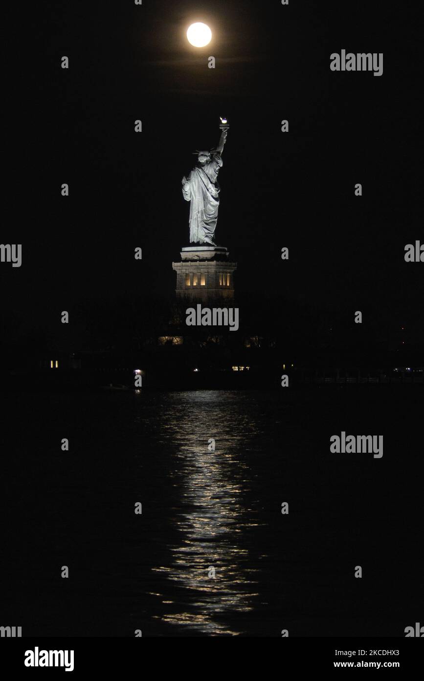 The Super Flower Moon rises behind the Statue of Liberty in New York ...