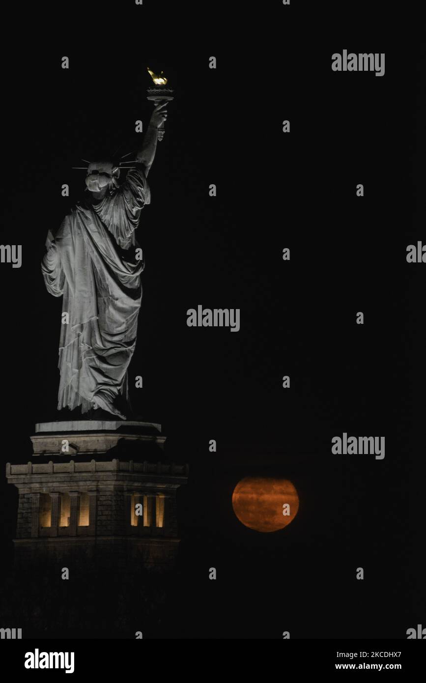 The Super Flower Moon rises behind the Statue of Liberty in New York ...