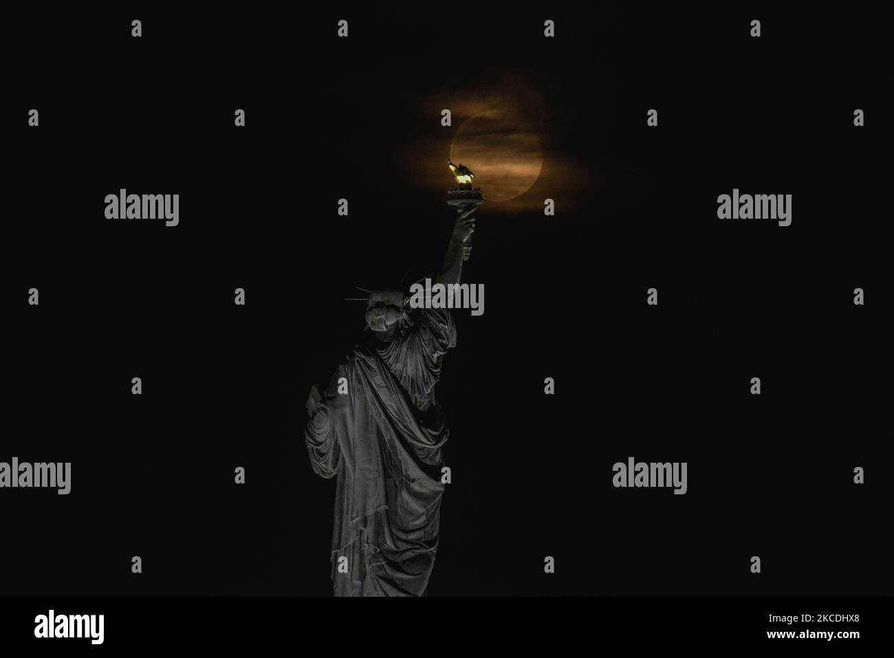 The Super Flower Moon rises behind the Statue of Liberty in New York ...