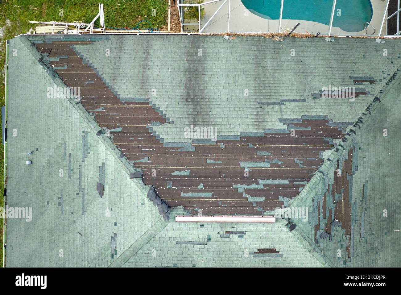 Damaged house roof with missing shingles after hurricane Ian in Florida ...