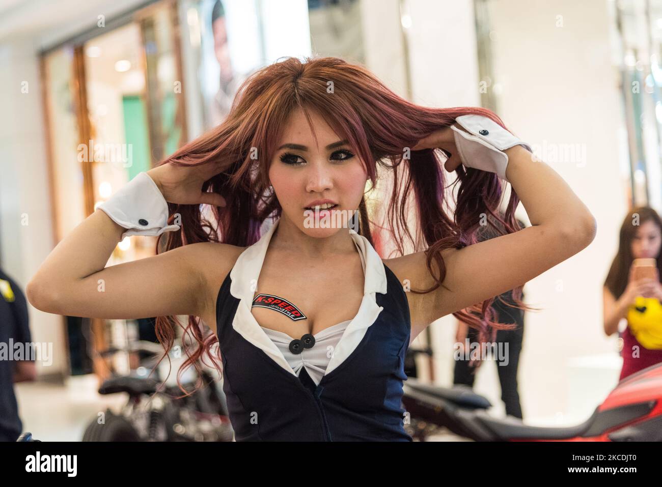 A ''pretty'', promotional model, poses around a stand for Ducati bikes ...