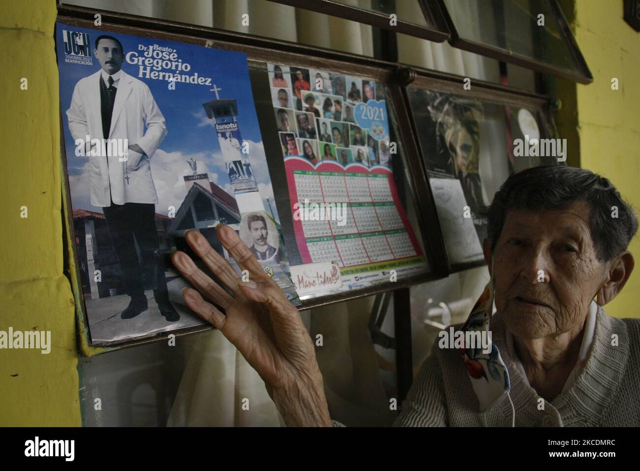 A woman poses near posters in honour of Venezuelan saint Jose Gregorio ...