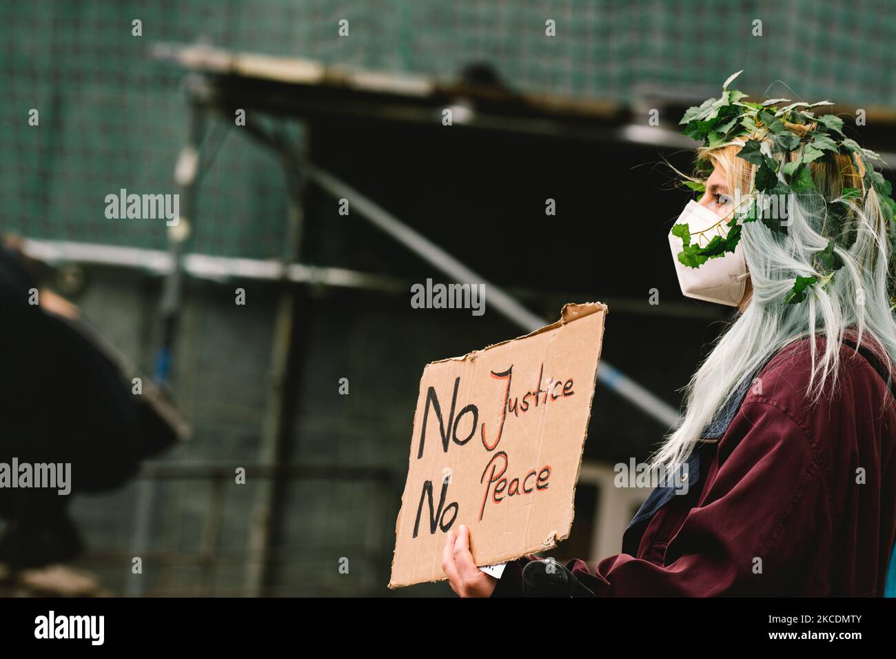 a woman with " no justice, no peace" sign is seen during the Women ...