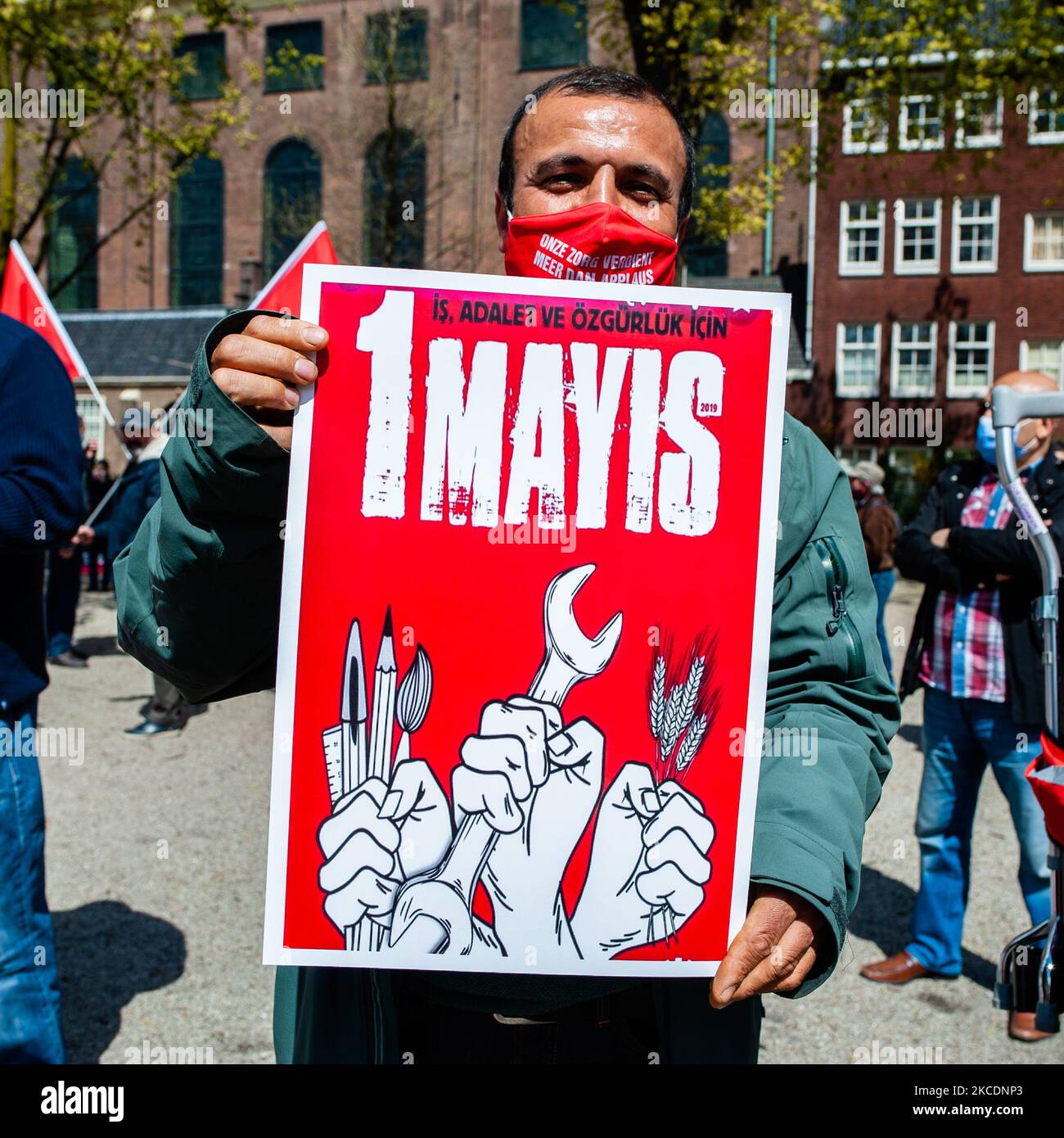A man is holding a Turkish poster in solidarity with workers day in ...