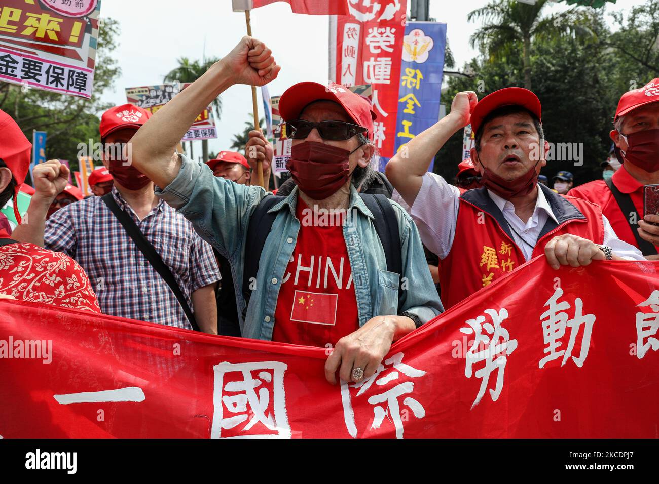 Man with a Pro CCP Tshirt marching with flags, banners, and signs in ...