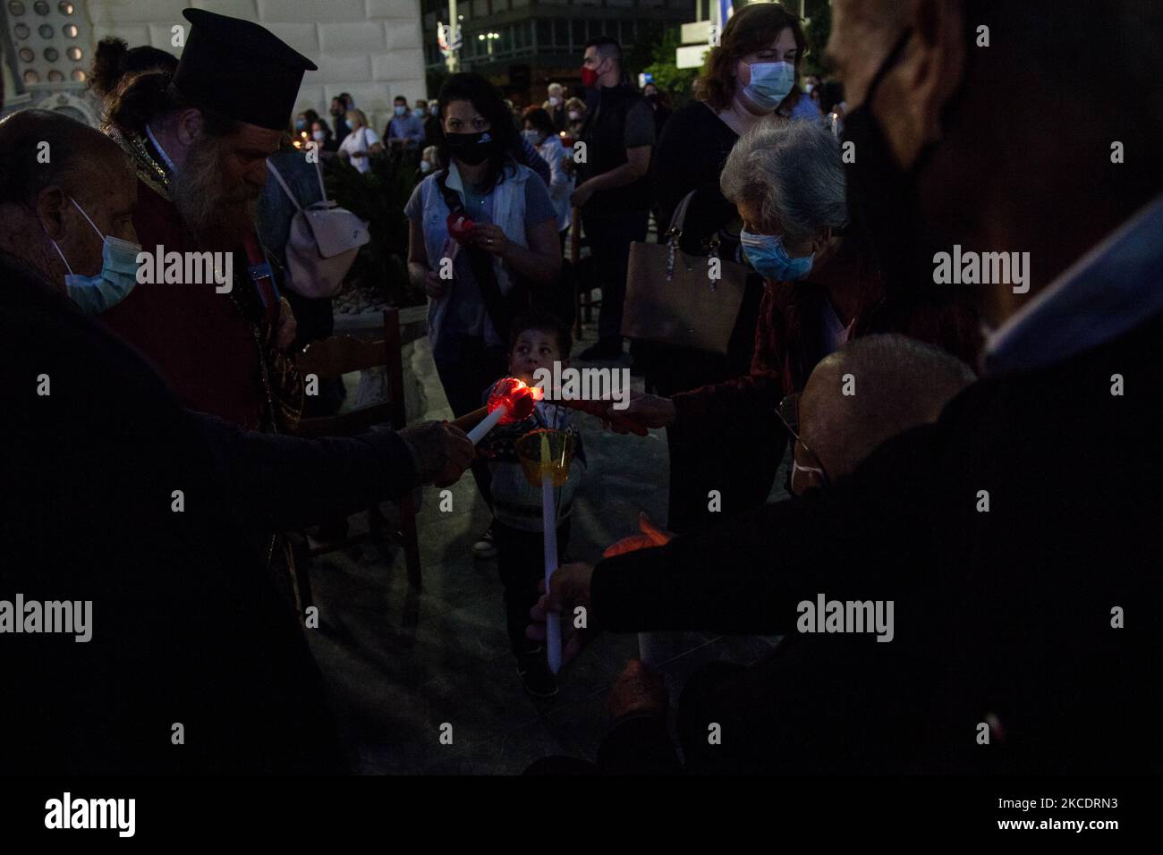A priest shares the holy light during the Jesus resurrection ceremony ...