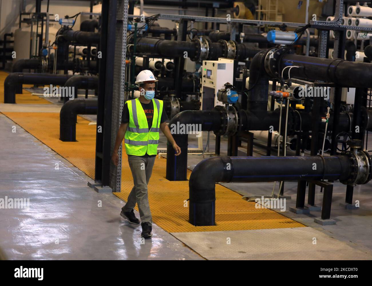 A Palestinian engineer works at a plant to convert seawater into fresh ...