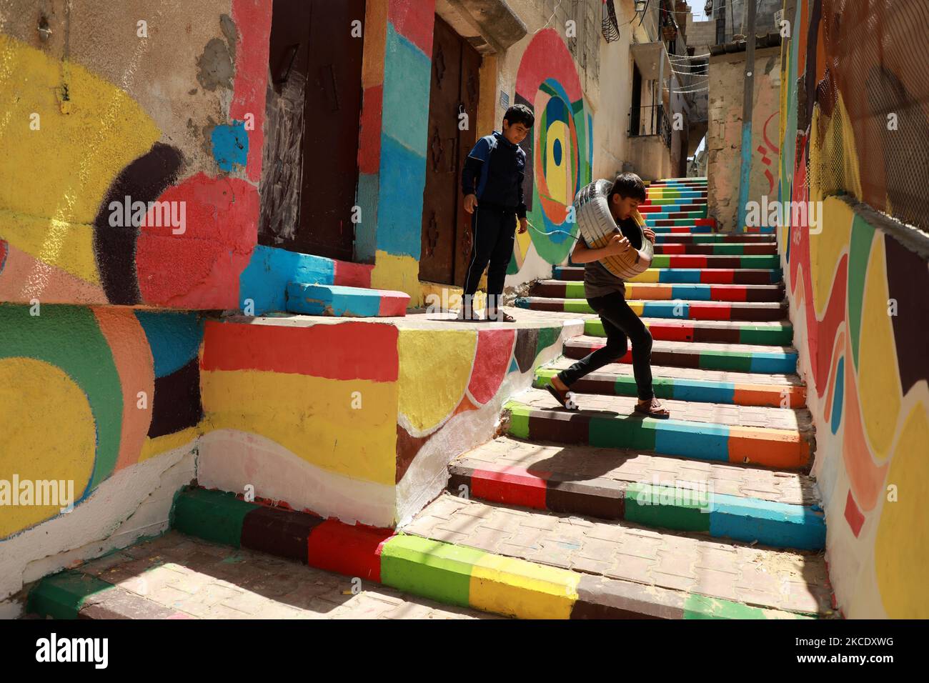 Palestinian boys play down steps decorated with vibrant colours in the ...