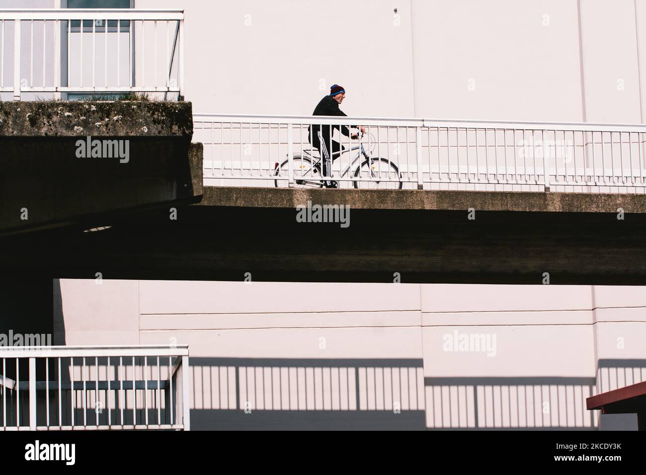 A man with bicycle is seen passing the high building in Chorweiler ...