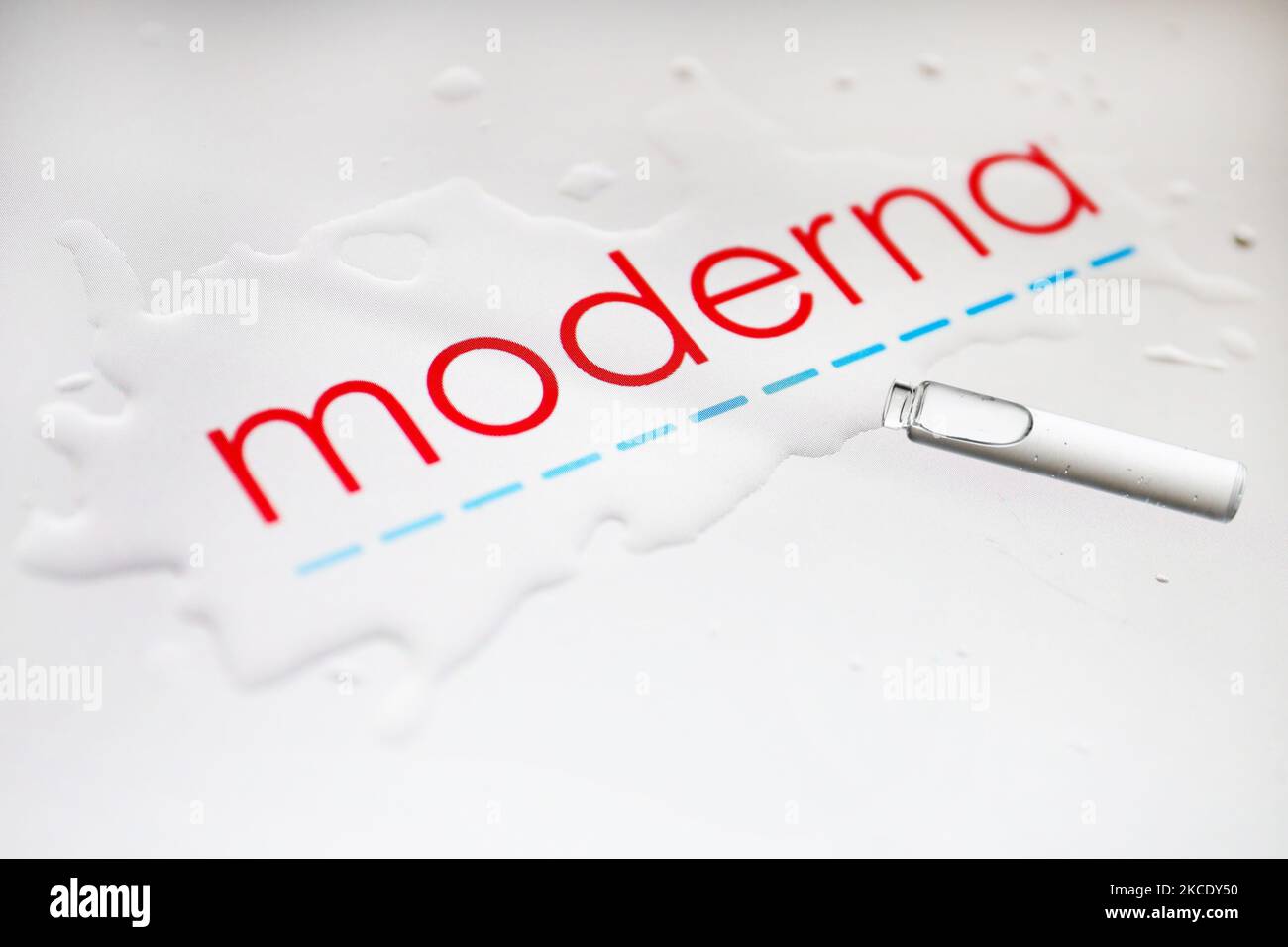 Moderna vaccine manufacturer logo is photographed with a vial and ...