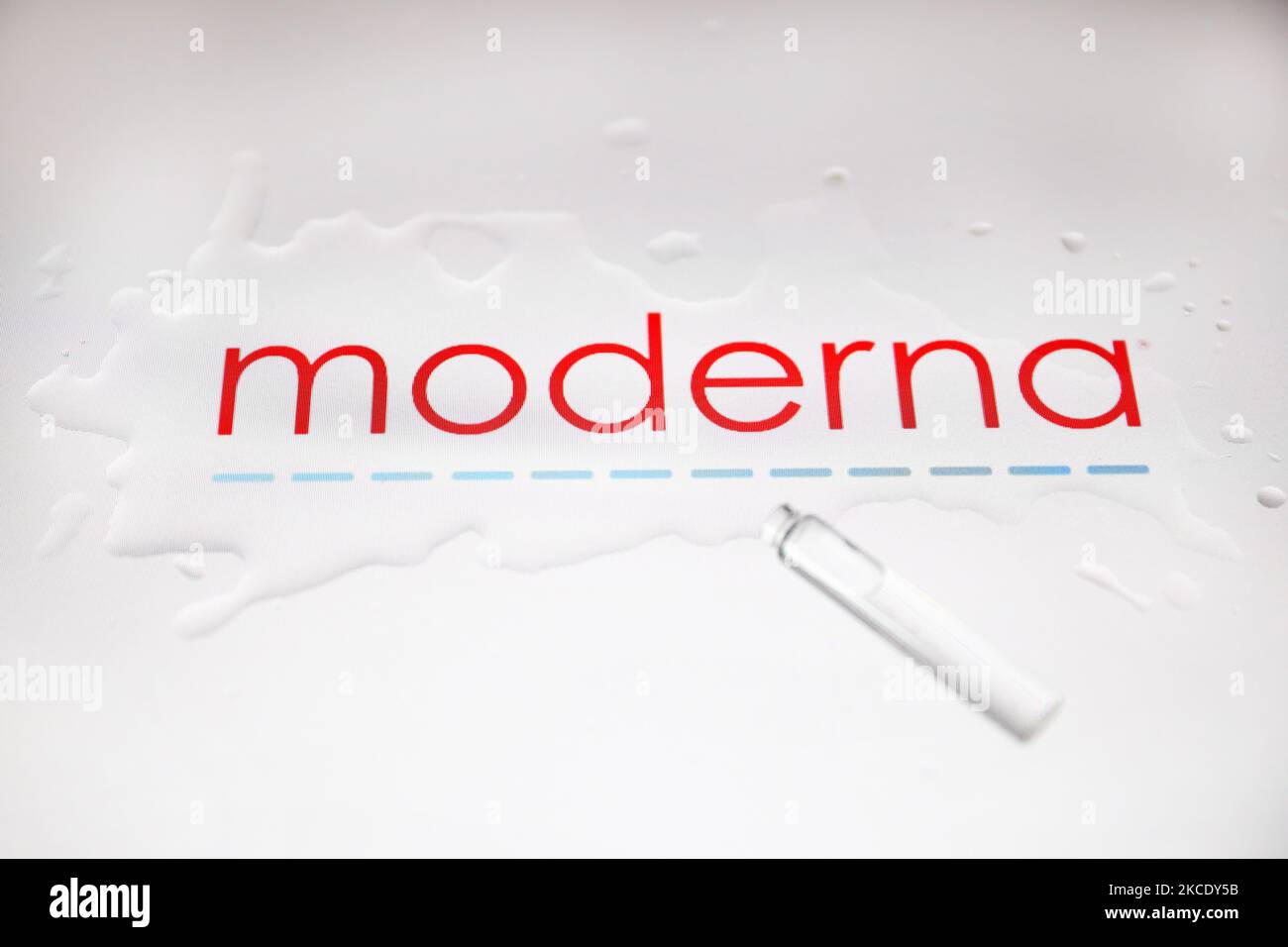 Moderna vaccine manufacturer logo is photographed with a vial and ...