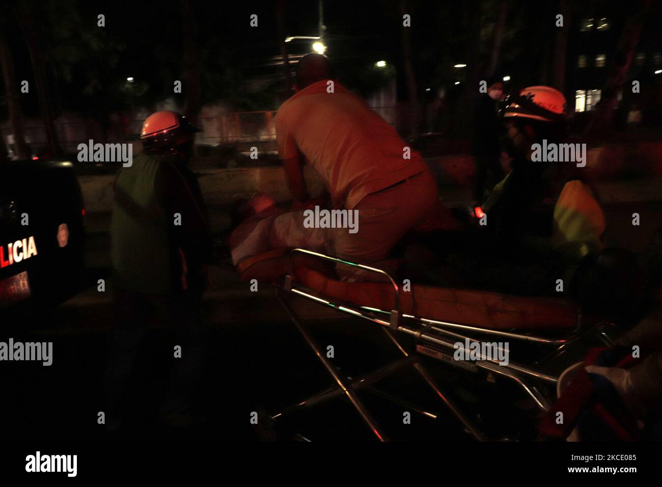 Paramedics try to resuscitate a person on a stretcher with first aid ...