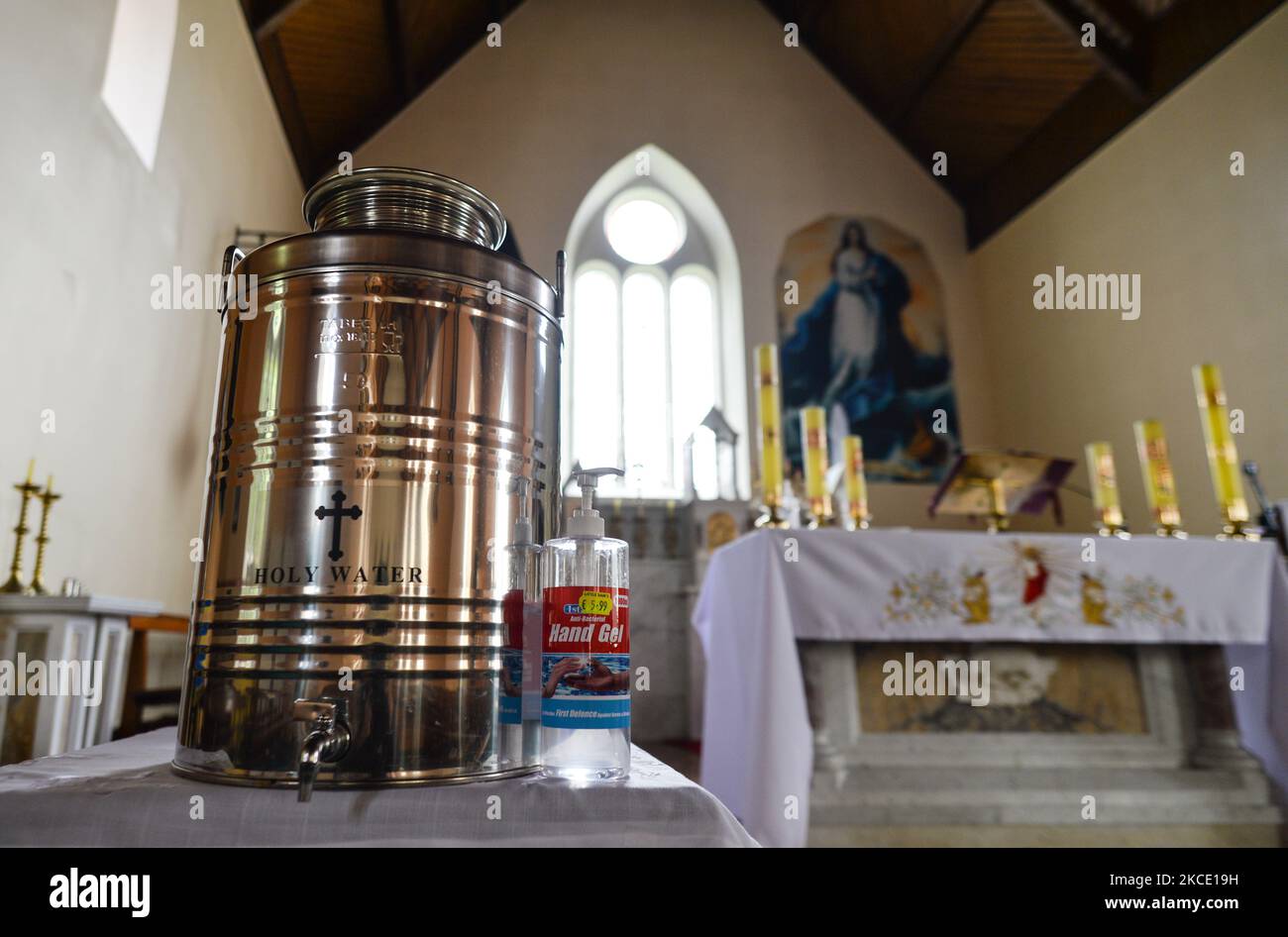 A container with holy water next to the hand sanitizer visible inside ...