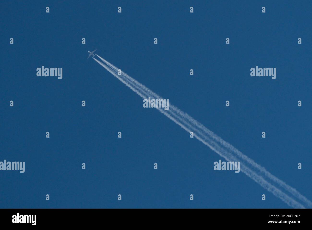 A flying plane leaves a mark on the blue sky above Roundstone Bay as ...