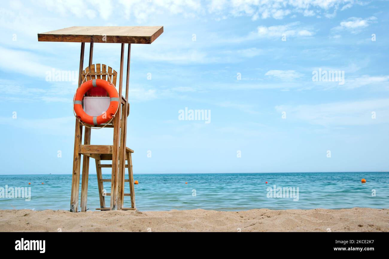 Emplty wooden lifeguard station on sandy beach on ocean shore in summer ...