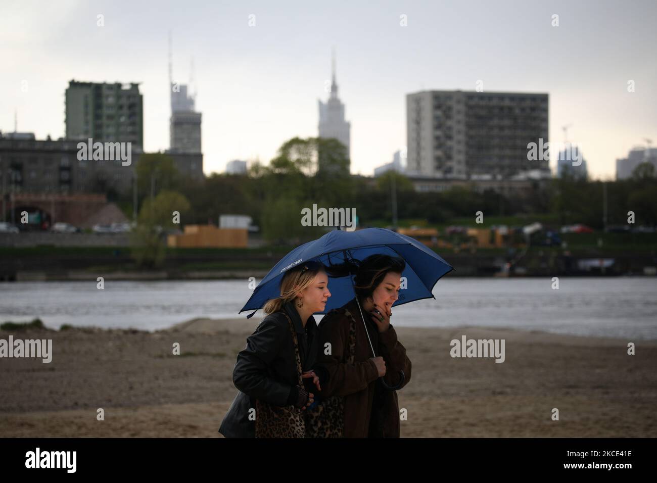 People are seen on the Poniatowka beach during a short rain storm in ...