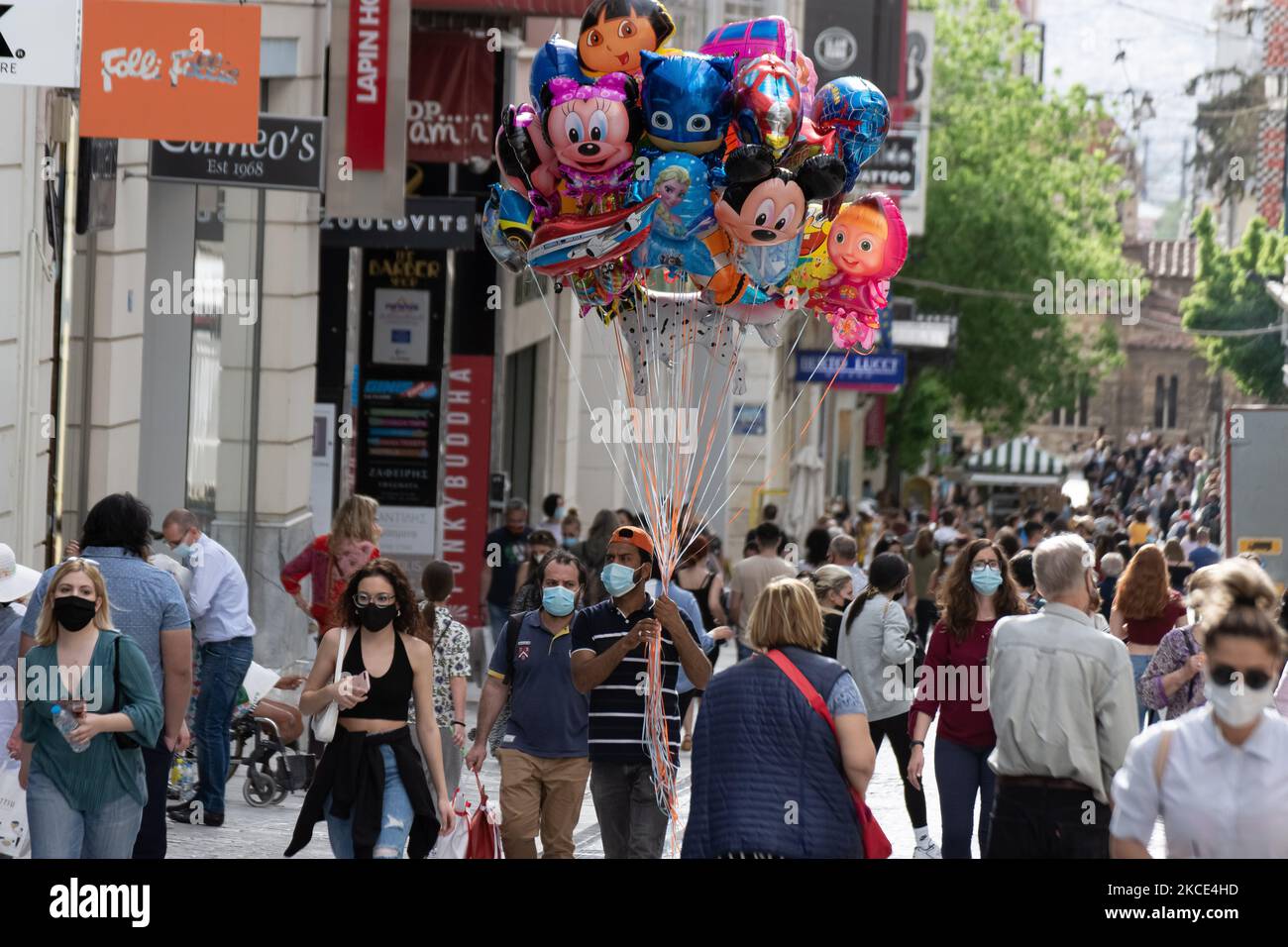 A man seen holding balloons at Ermou street in the center of Athens ...