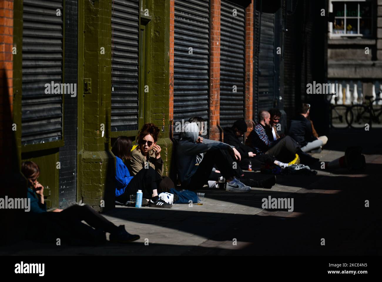 People sit outside a closed pub in Dublin city center during the final ...