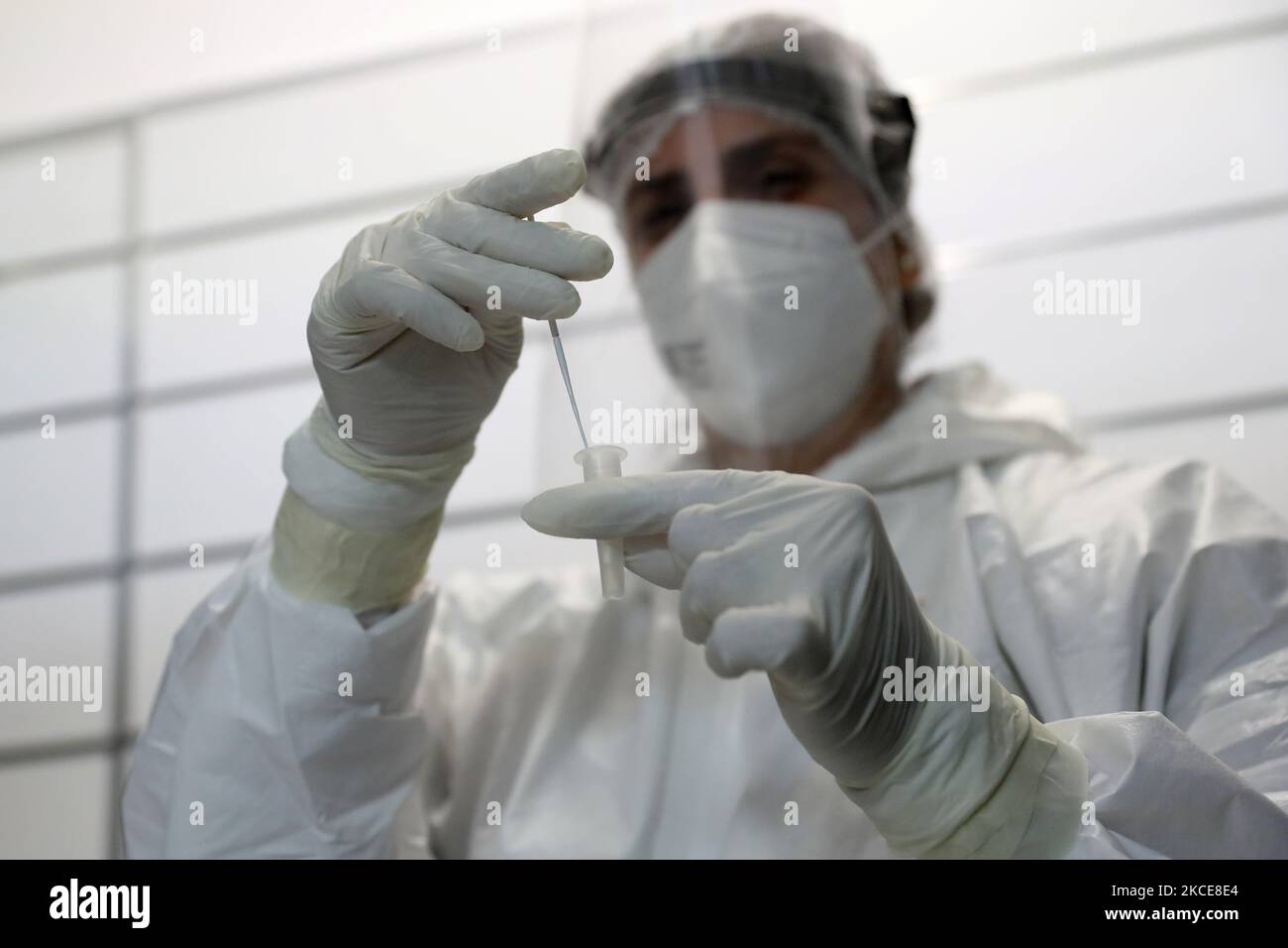 A health technician takes a sample from a spectator for a COVID-19 ...