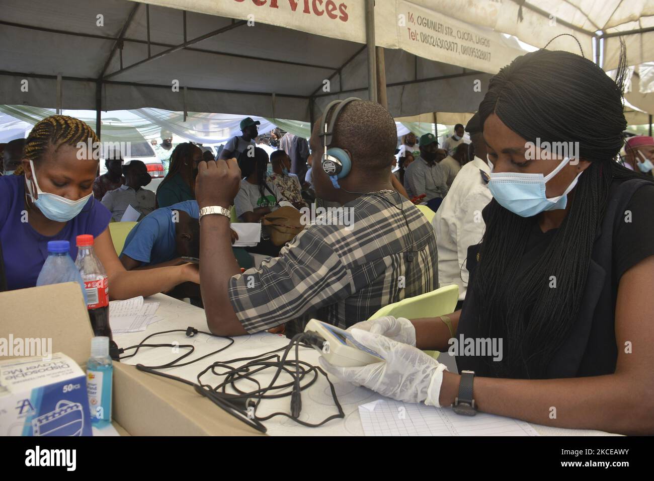 Health workers conducting hear checkup on a driver at Branch A, Biode ...