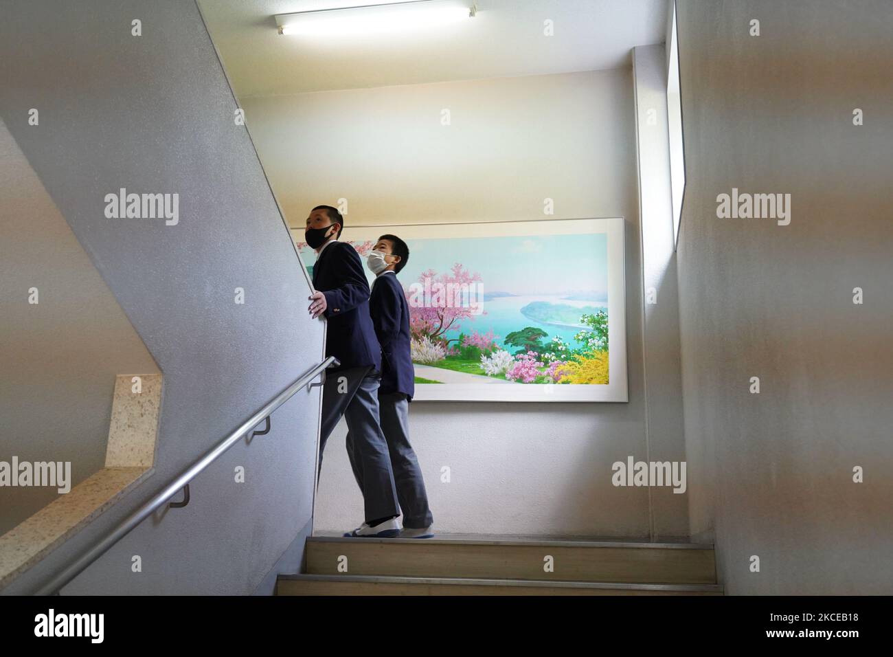 A painting of a spring Pyongyang scenery hang on a wall as two students ...