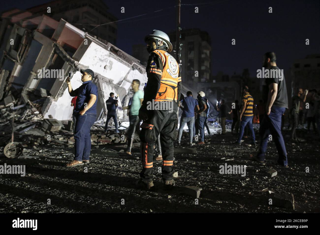 Palestinians gather in front of the rubble of the destroyed 13-storey ...