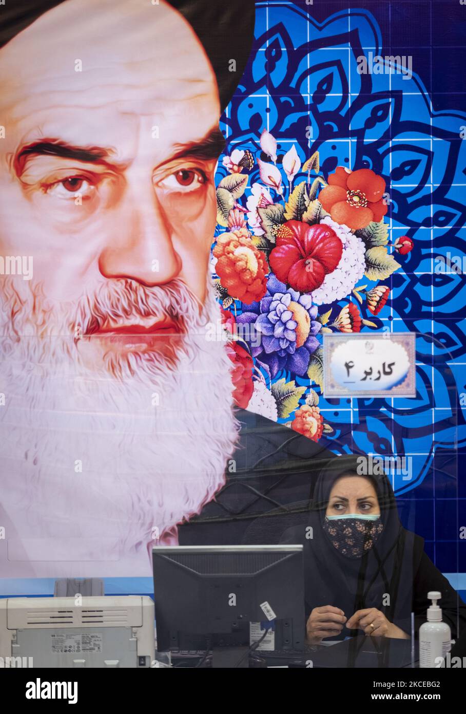 An Interior Ministry official wearing a protective face mask sits under ...