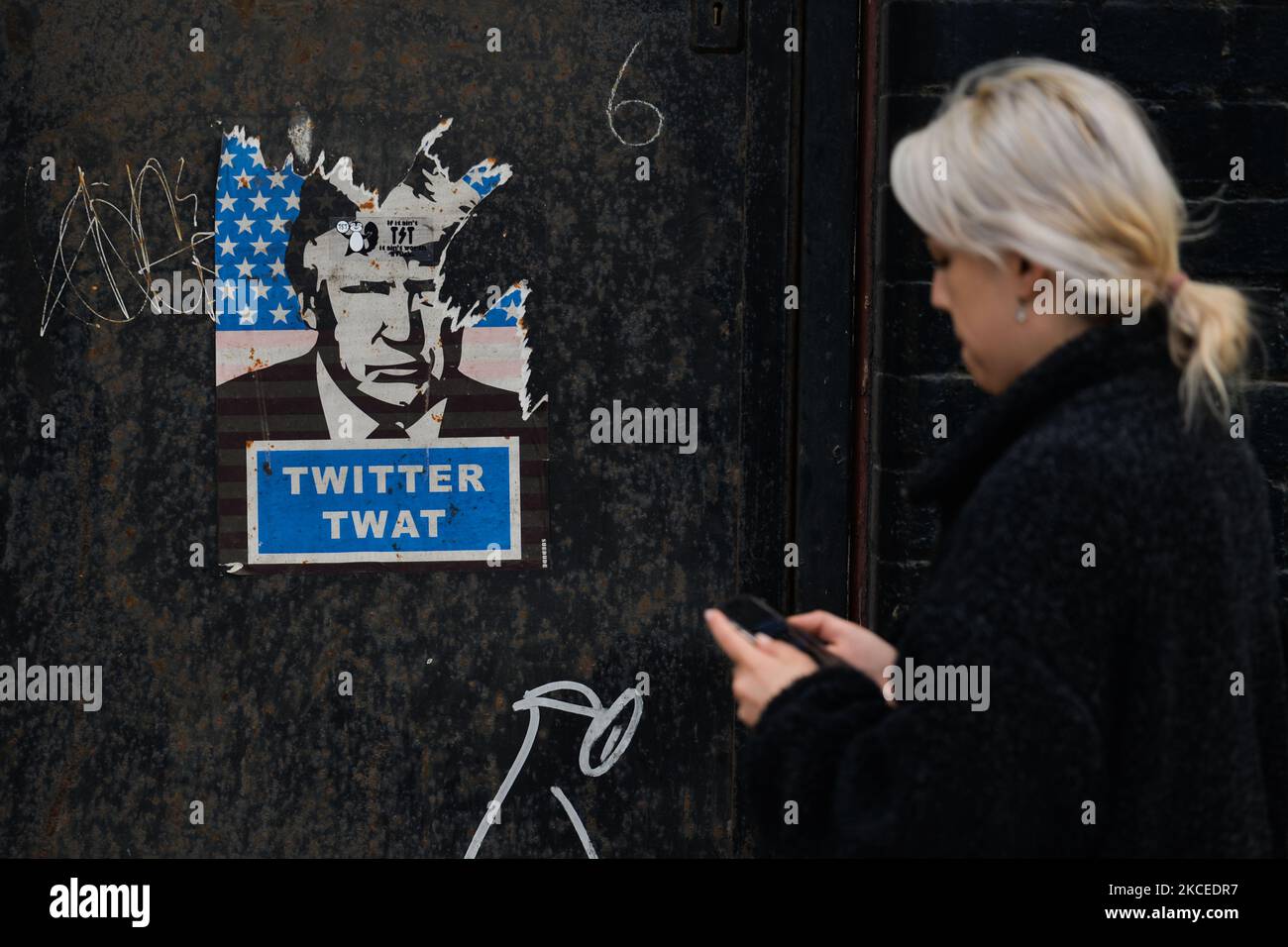 A woman walks past a poster with an image of former US President Donald ...