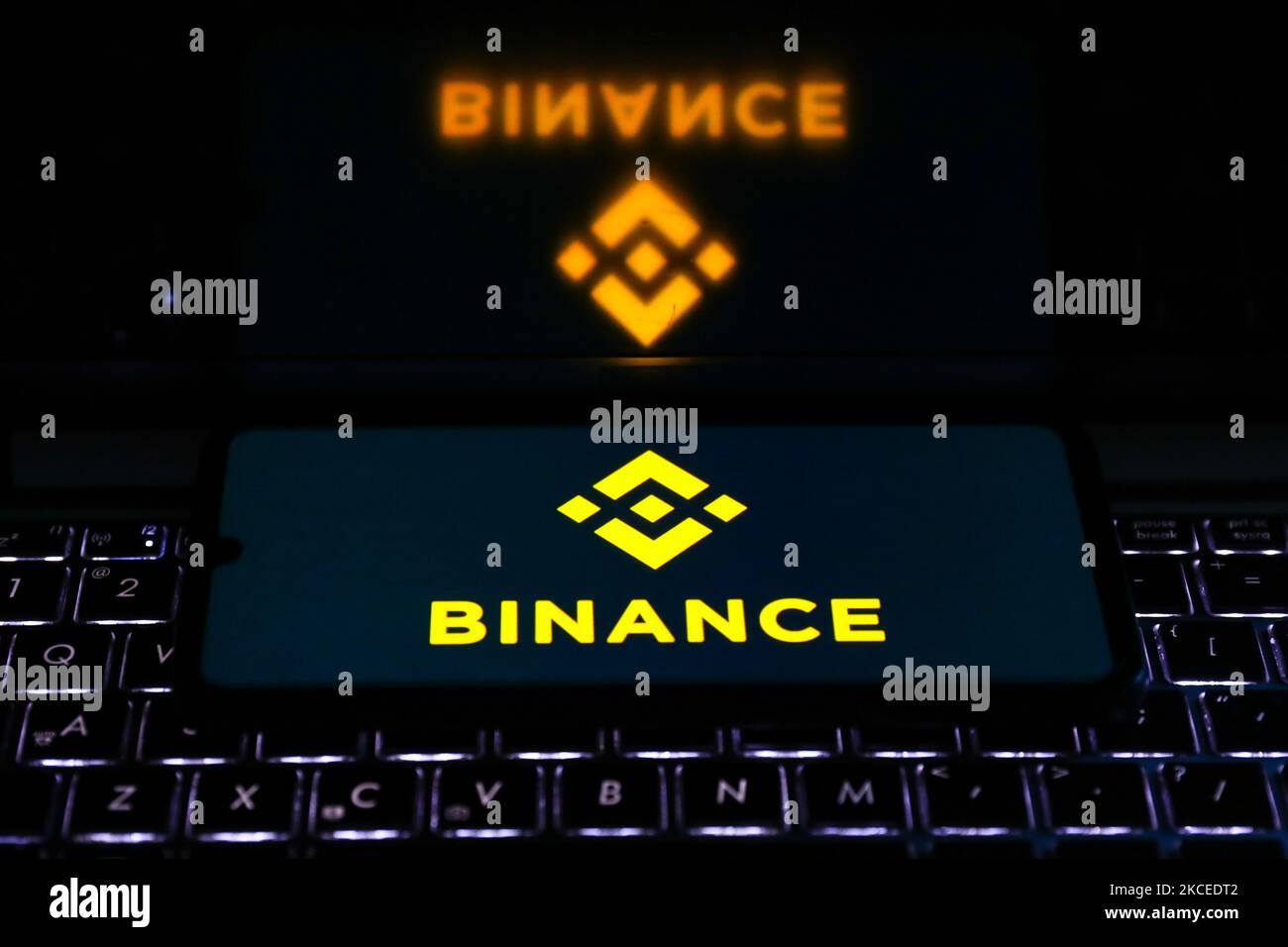 Binance logo is displayed on a mobile phone screen photographed for ...