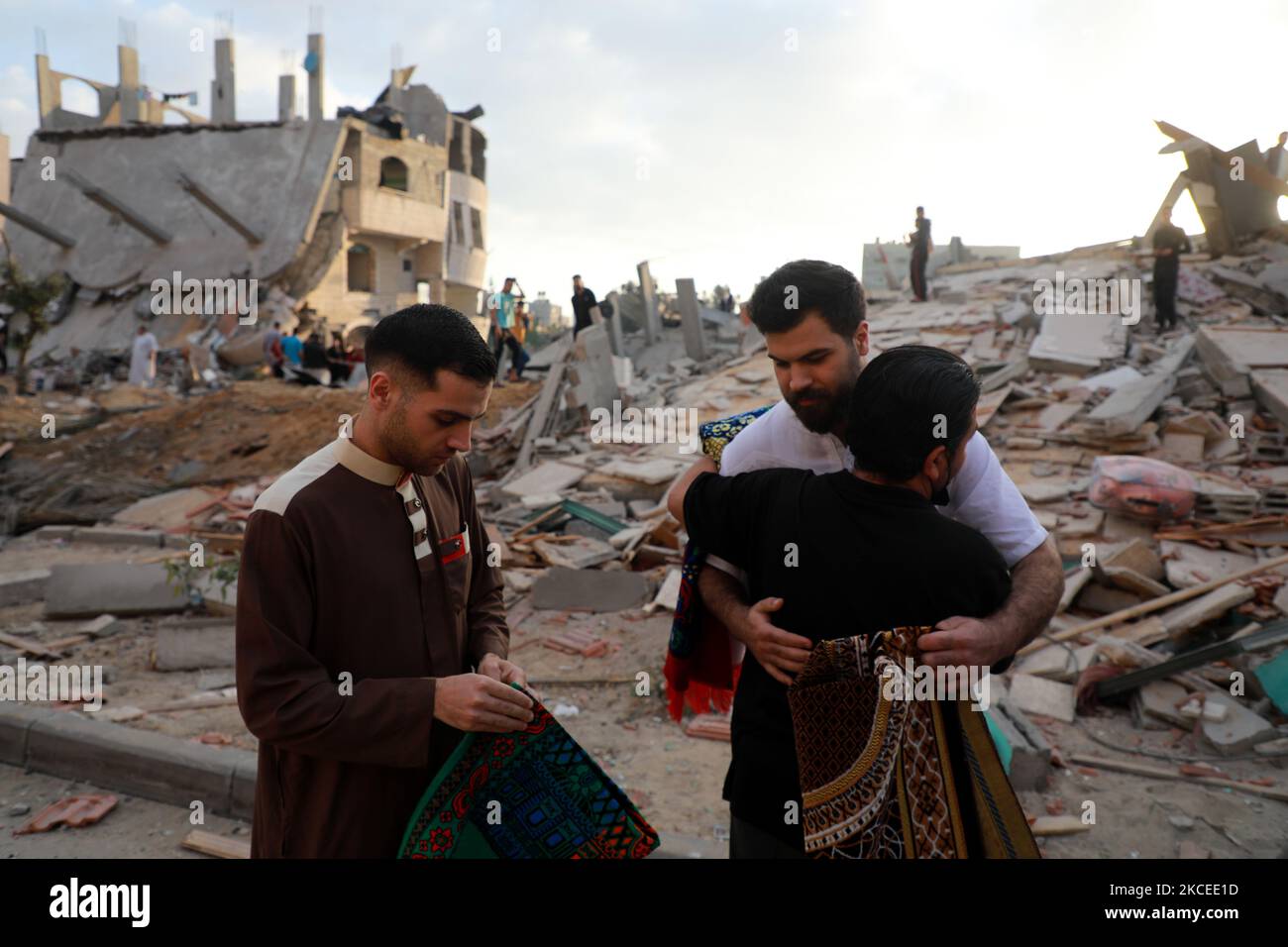 Palestinian Muslim men exchange Eid al-Fitr holiday wishes in front of ...