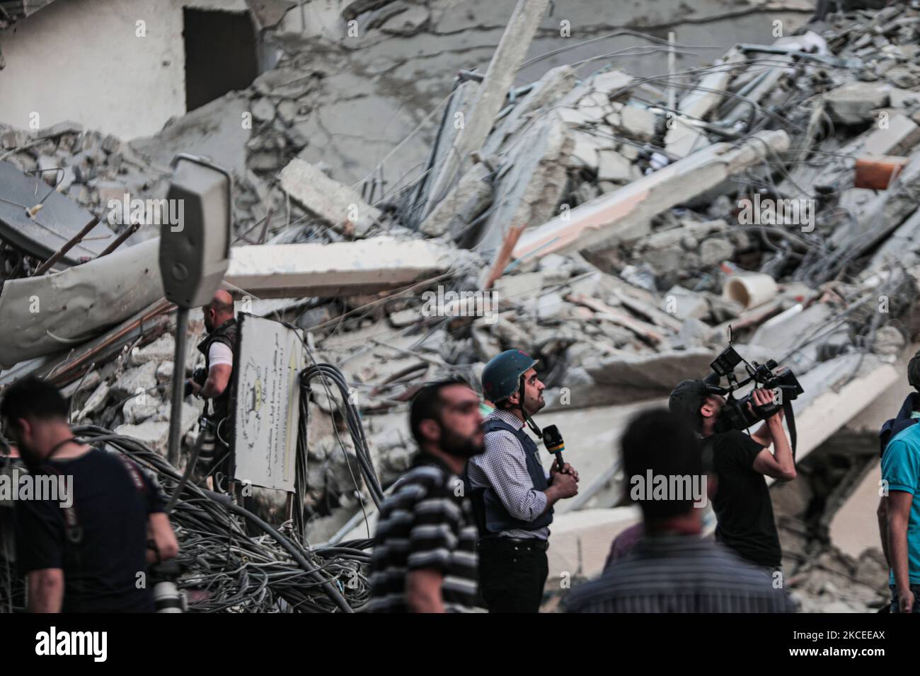 People inspect the site of the collapsed Al-Shorouk Tower building ...