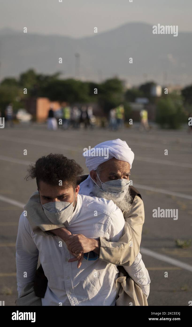An Afghan Sunni refugee man carrying his elderly father while arriving ...