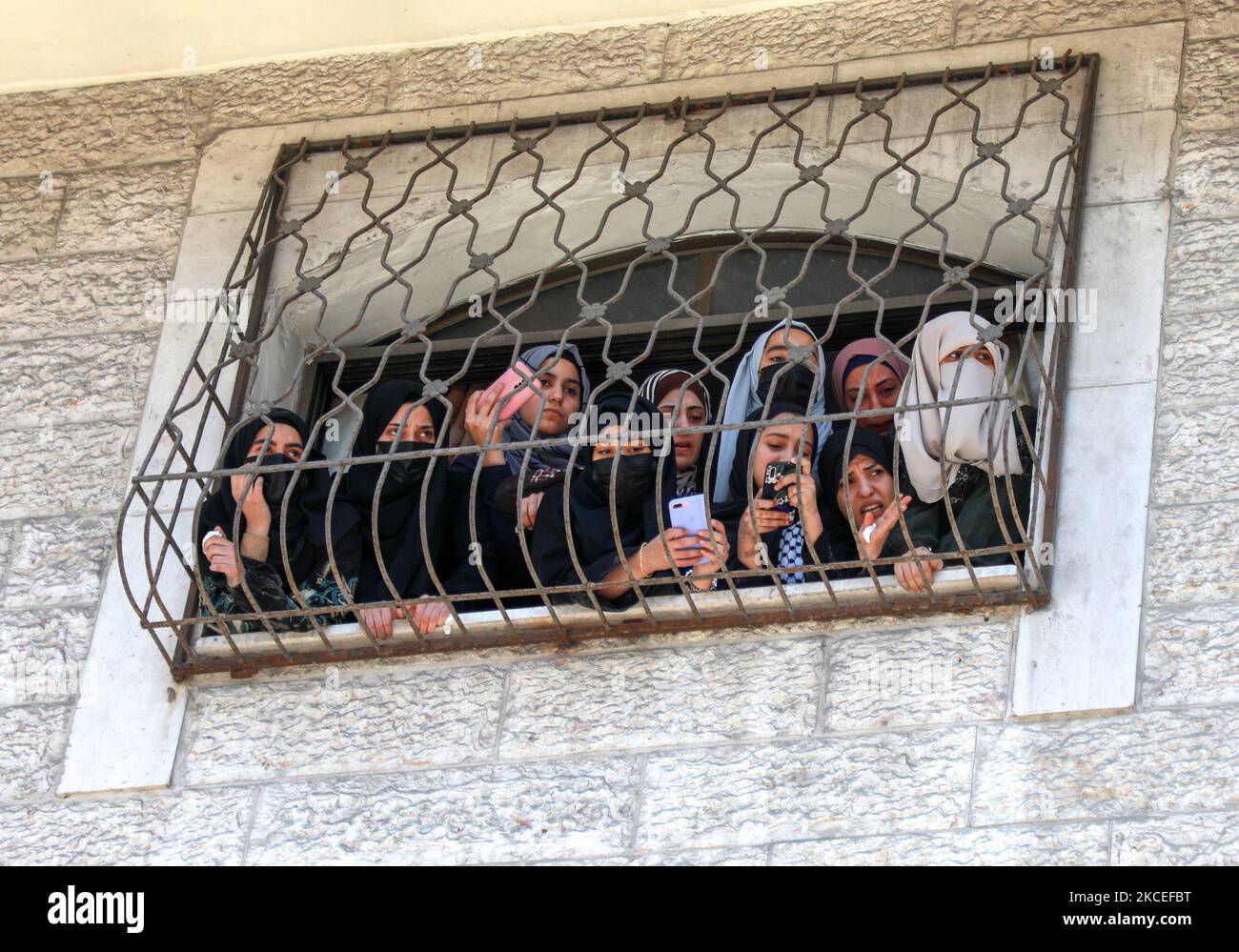 Palestinian women watch the funeral procession of Hamas military chief ...