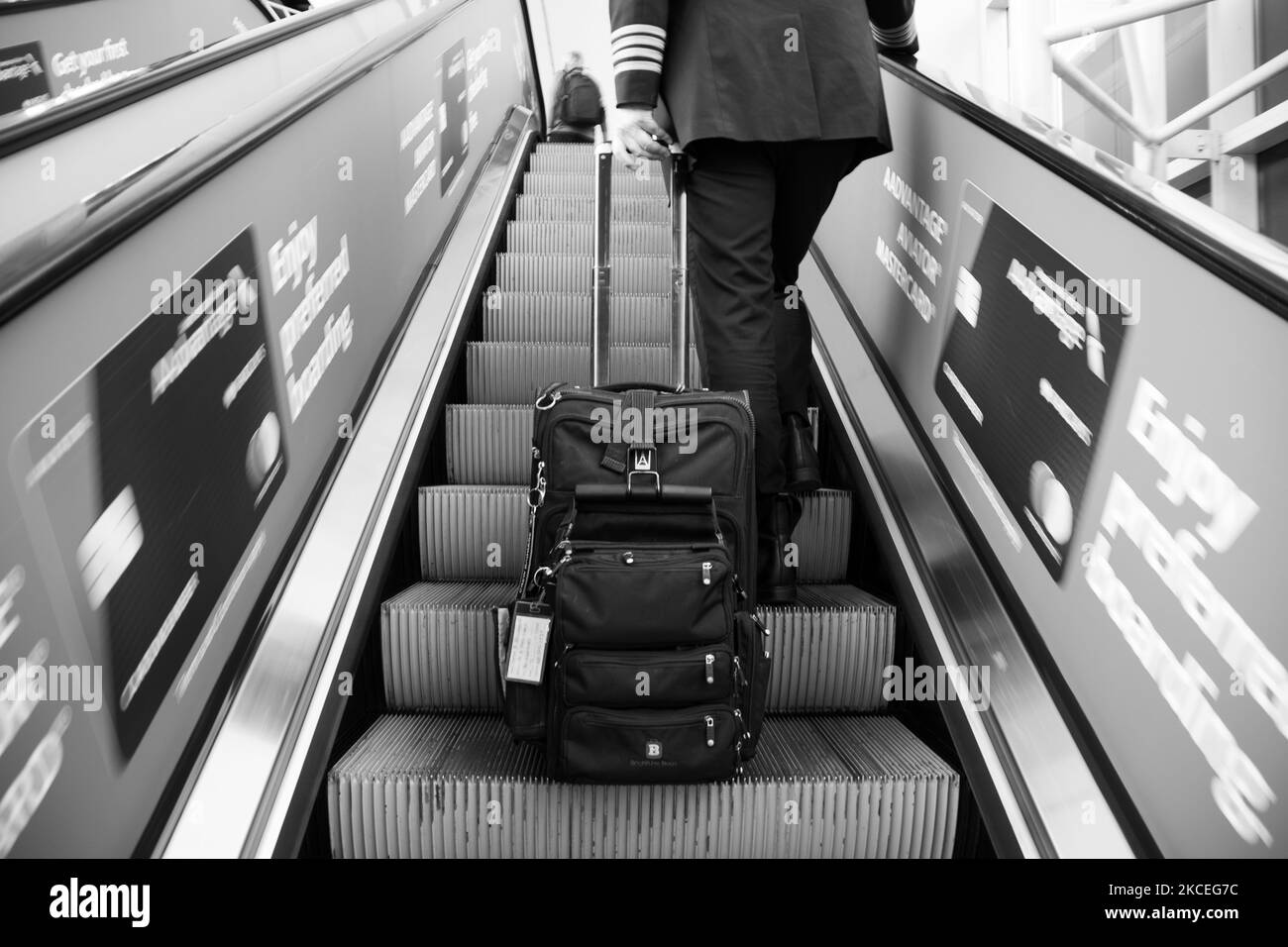A passenger rides the escalator on their way to board their next flight ...