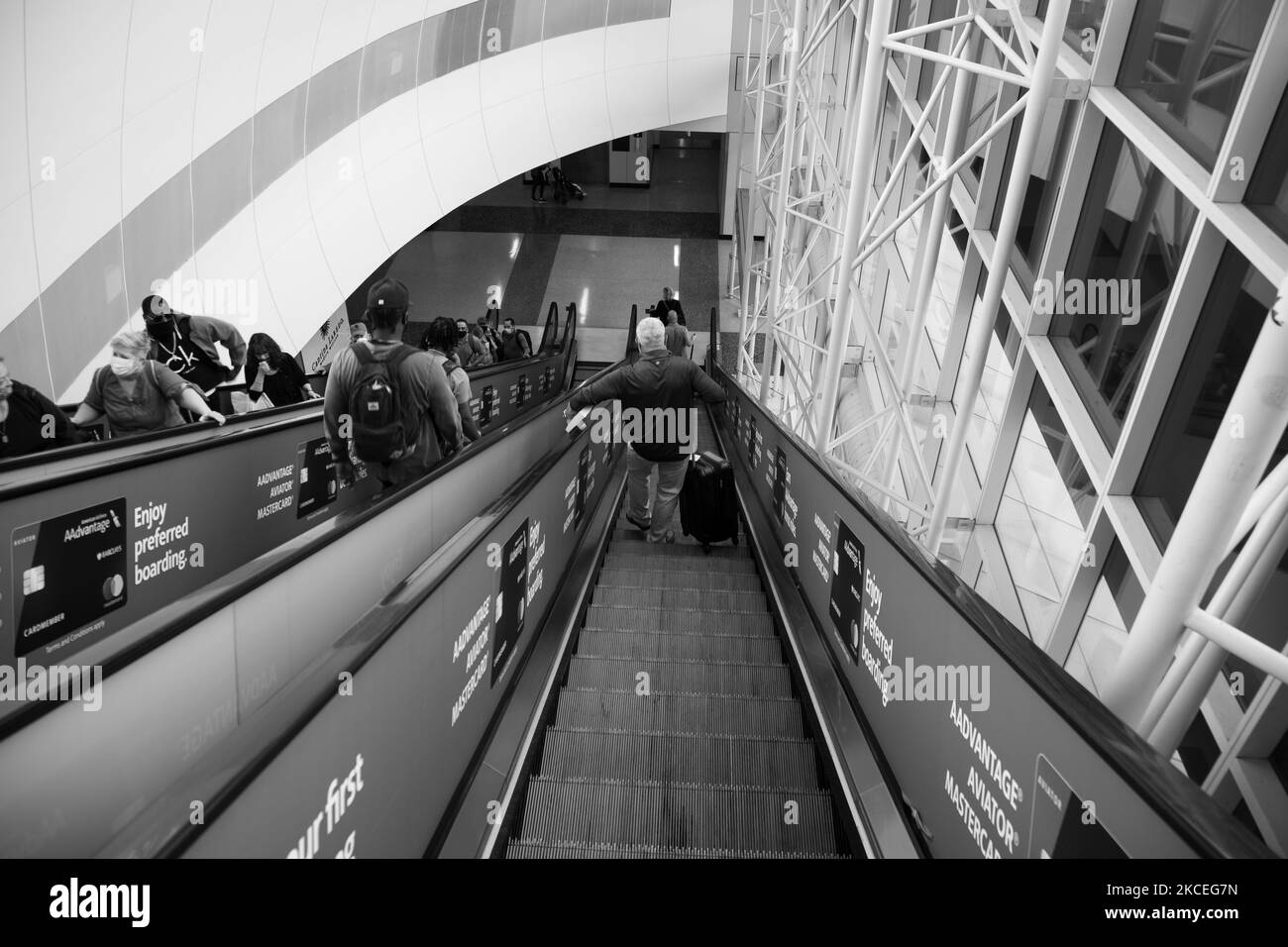 A passenger rides the escalator on their way to board their next flight ...