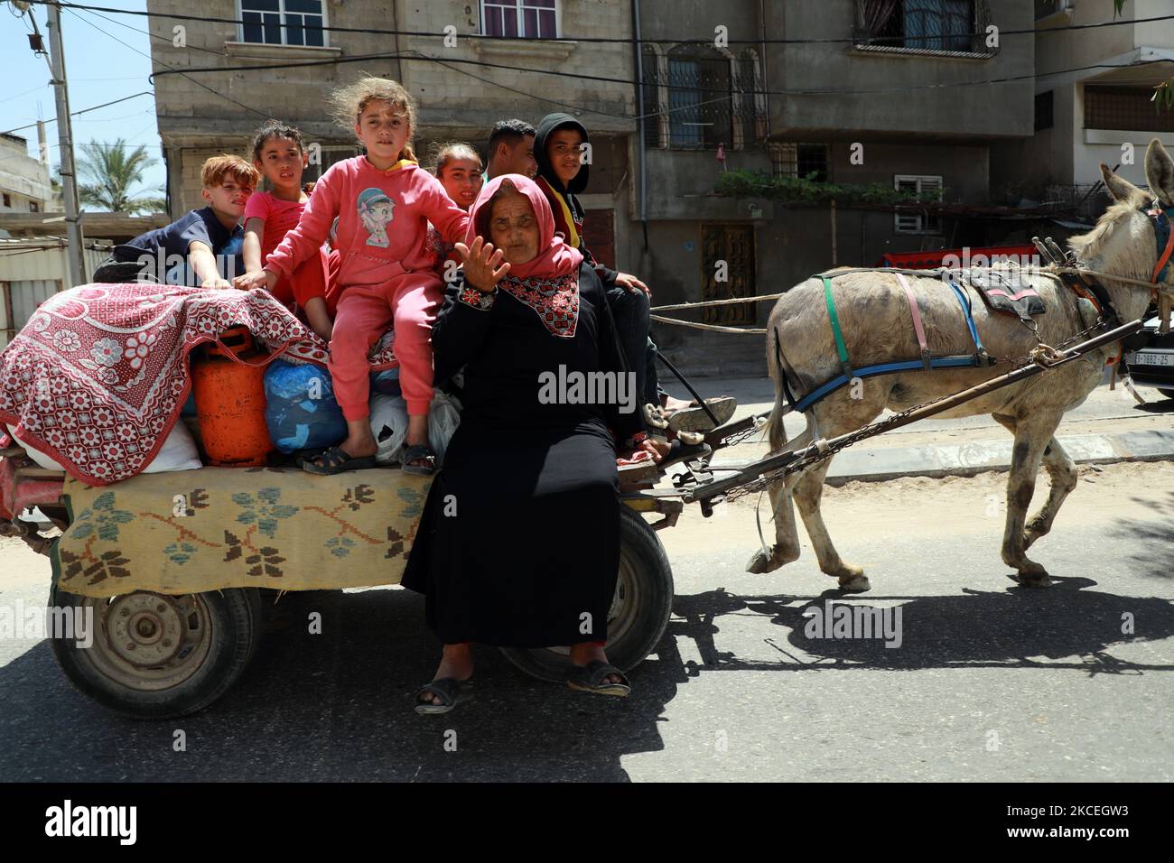 Palestinians riding on a donkey-drawn cart flee their homes during ...