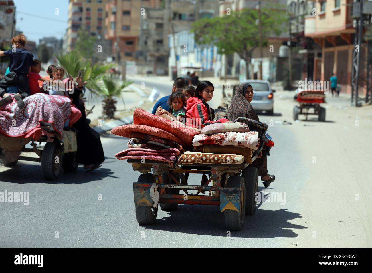 Palestinians riding on a donkey-drawn cart flee their homes during ...