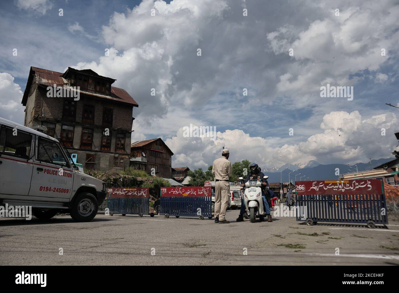 An Indian policeman stops civilian traffic on a blocked road during ...