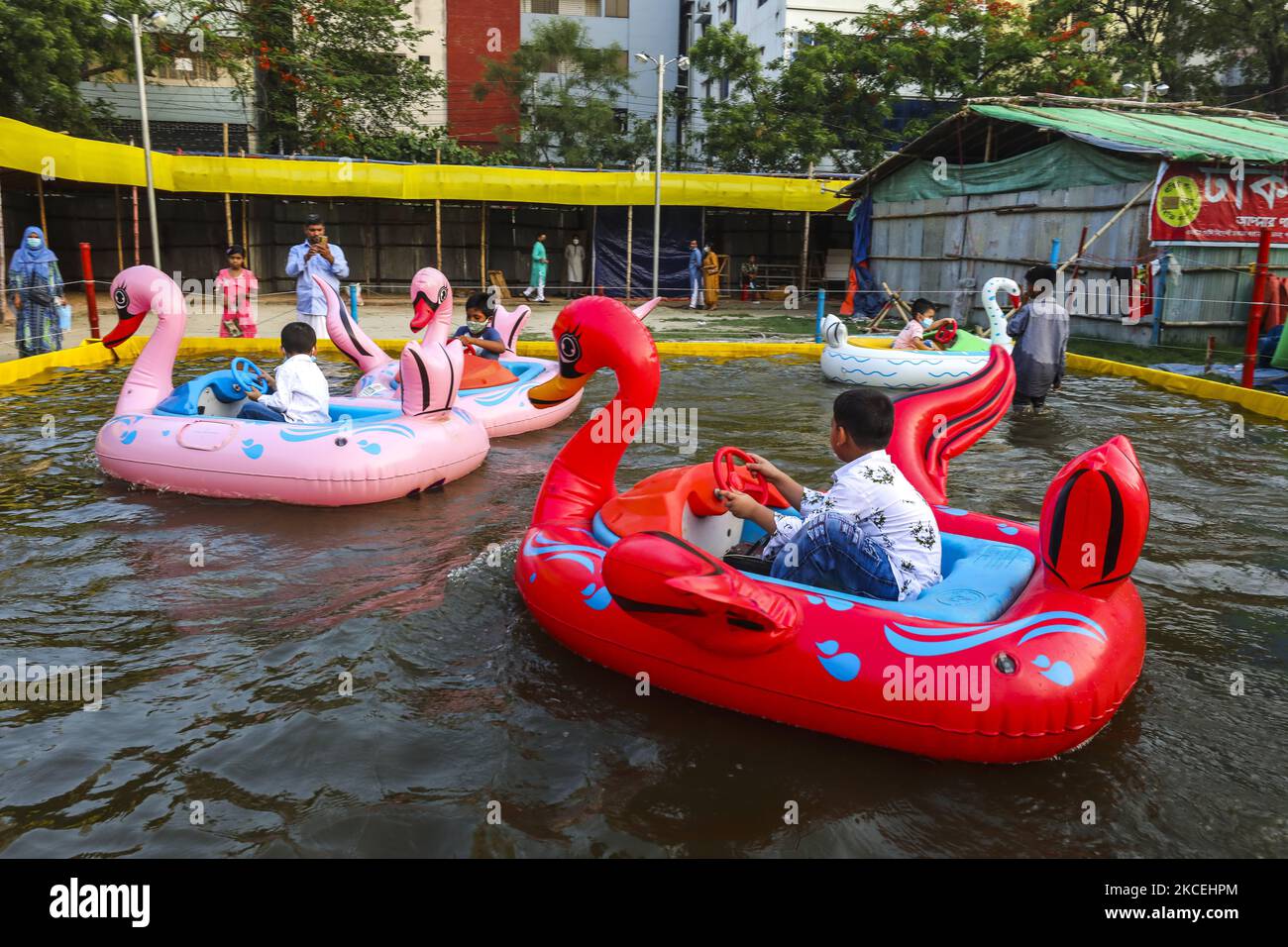 Children enjoy a ride at an makeshift amusement park during Eid al Fitr ...