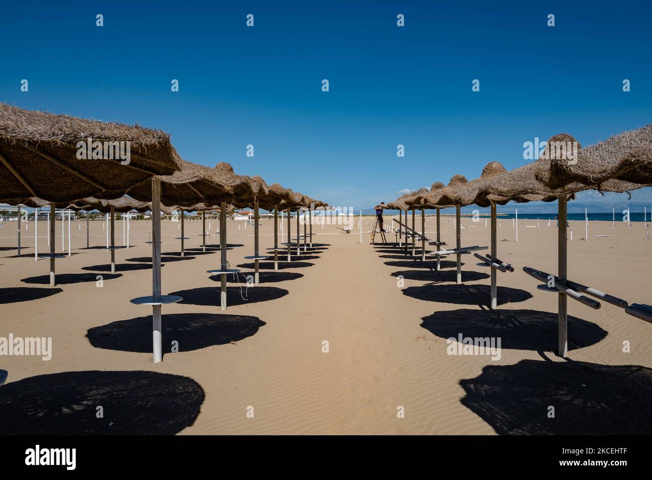 A worker prepares to fix the umbrellas on the beach of Margherita di ...