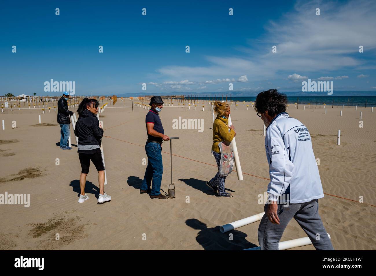 The owner of a bathing beach with the workers place the poles for the ...