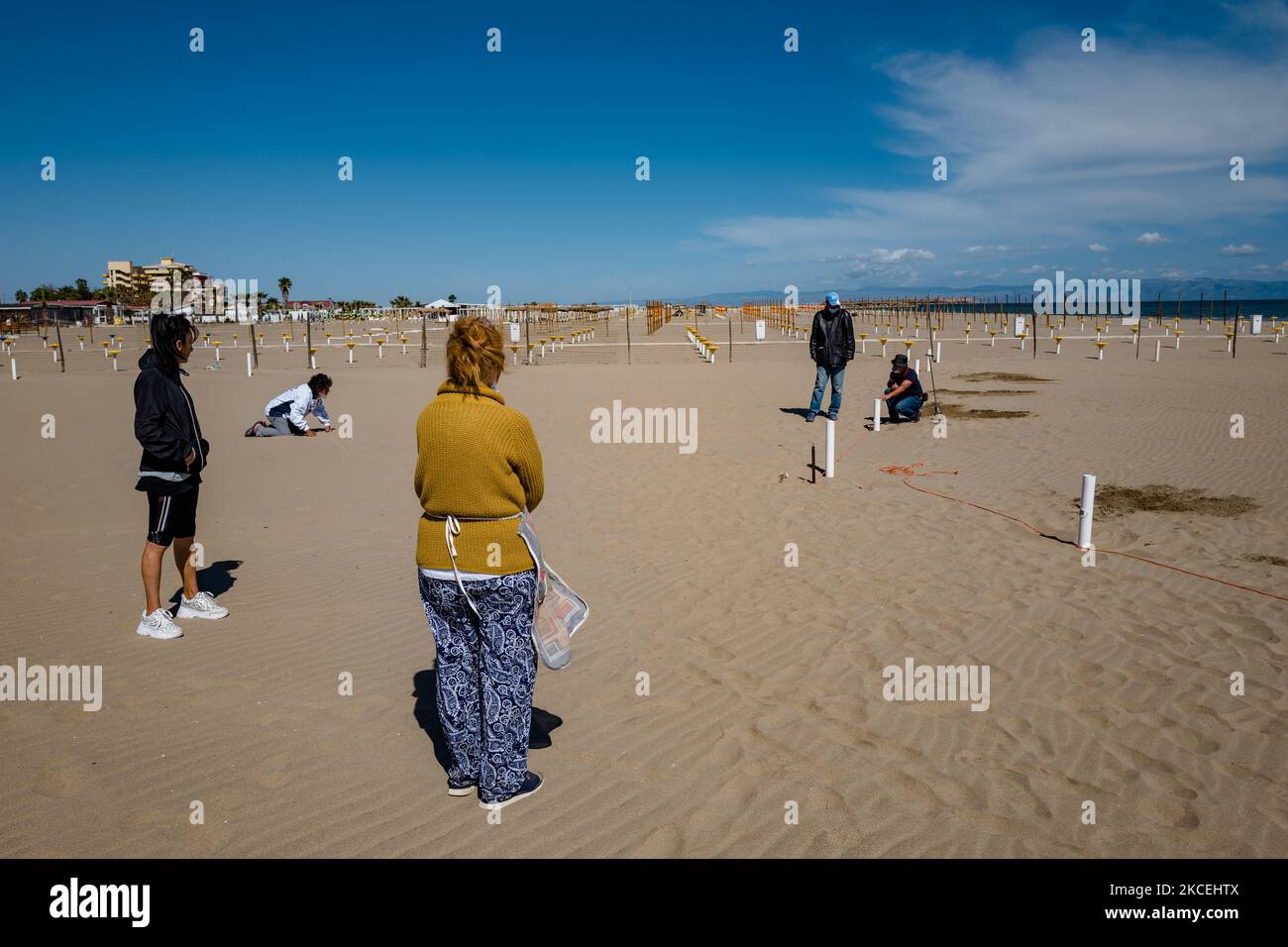 The owner of a bathing beach with the workers place the poles for the ...