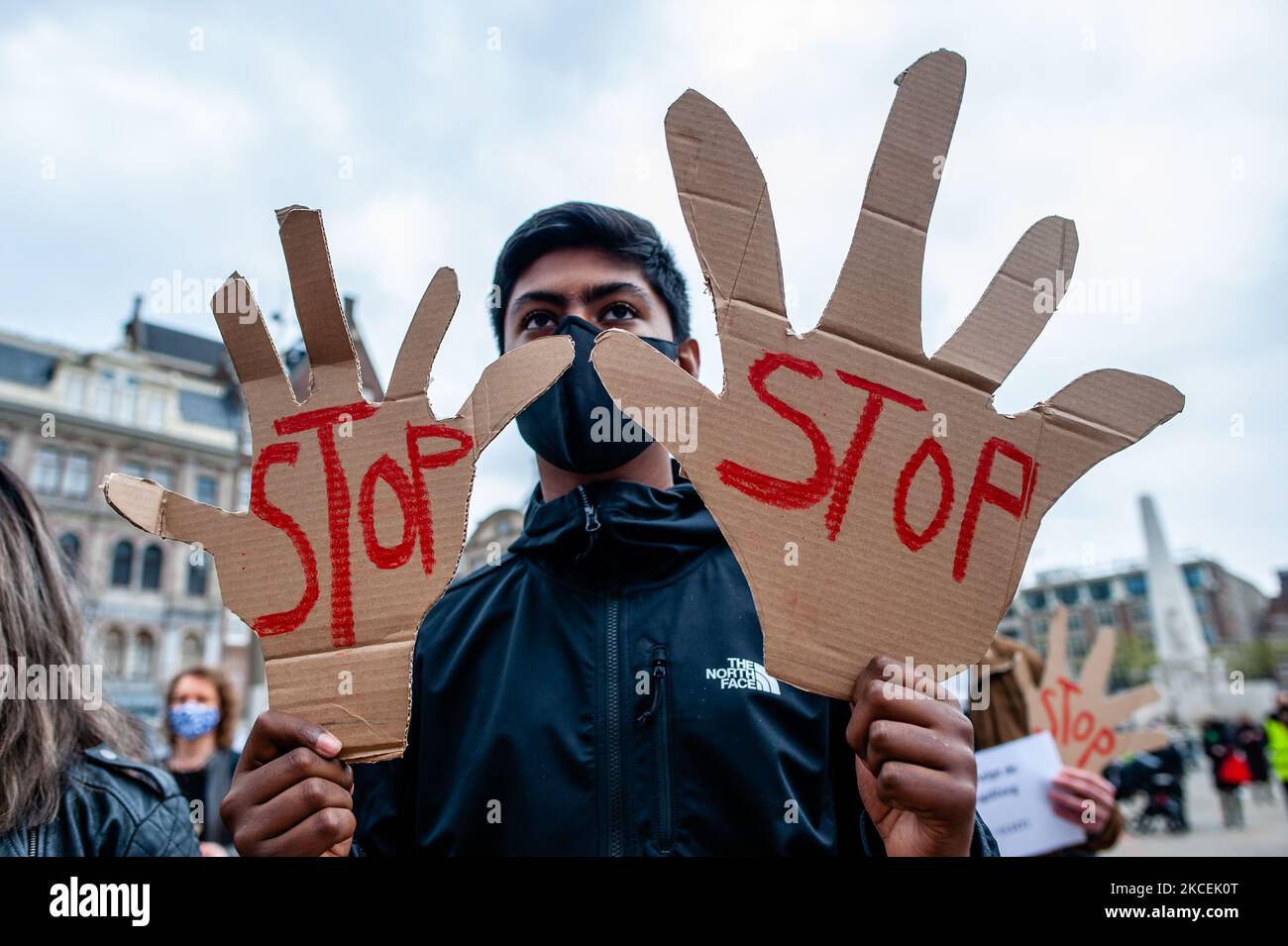 A man is holding a couple of carton hands with word stop drawn on ti ...