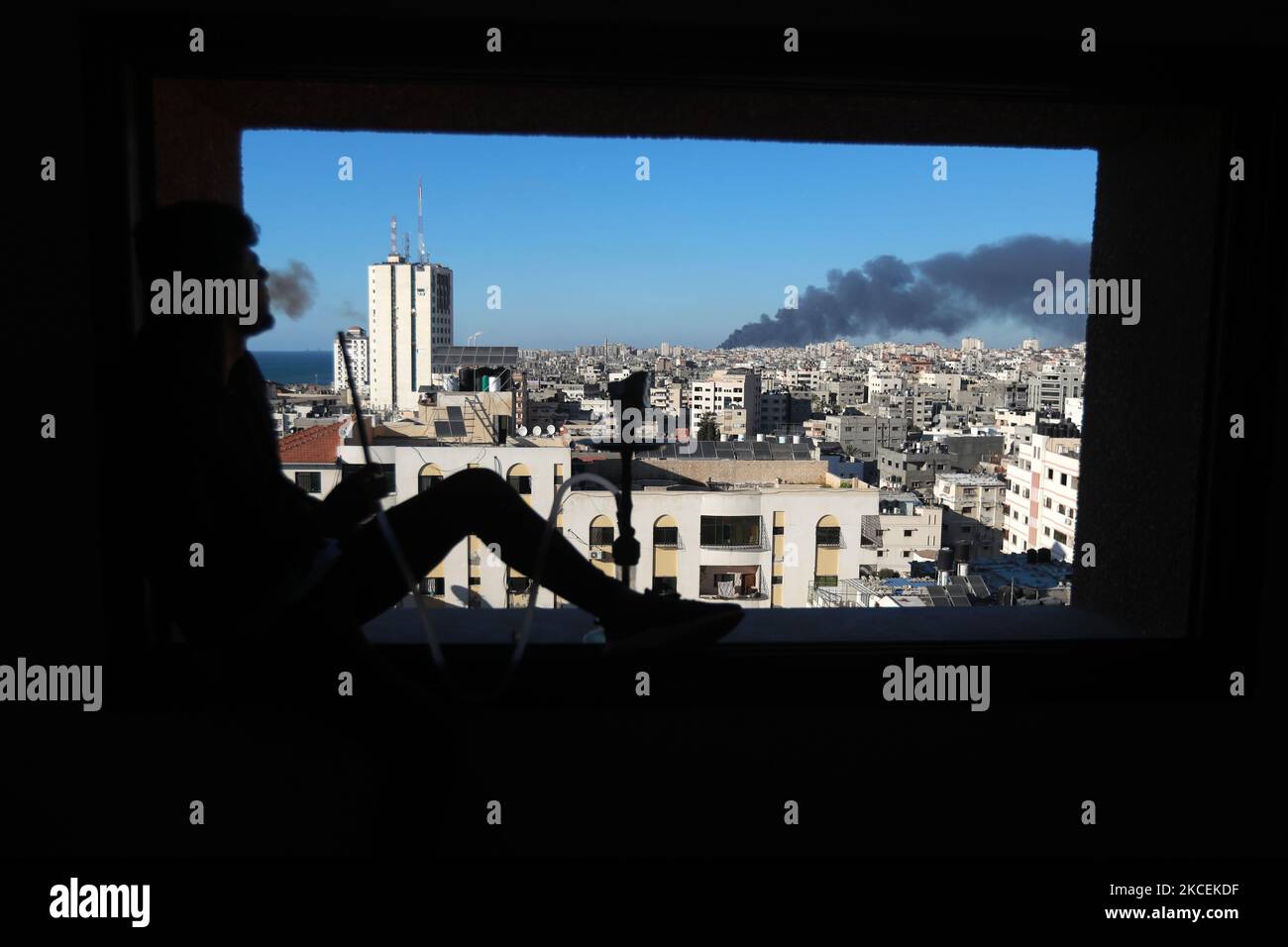 A Palestinian man smokes a waterpipe (shisha or hookah) as the rockets ...