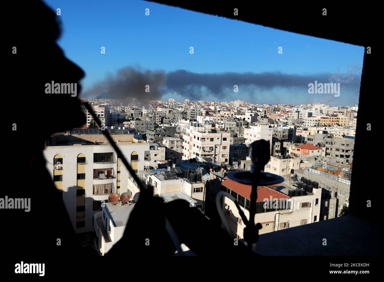 A Palestinian man smokes a waterpipe (shisha or hookah) as the rockets ...