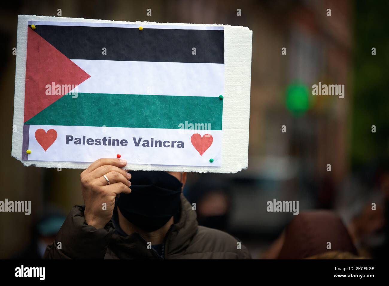 A man holds a placard with the flag of Palestine and reading 'Palestine ...